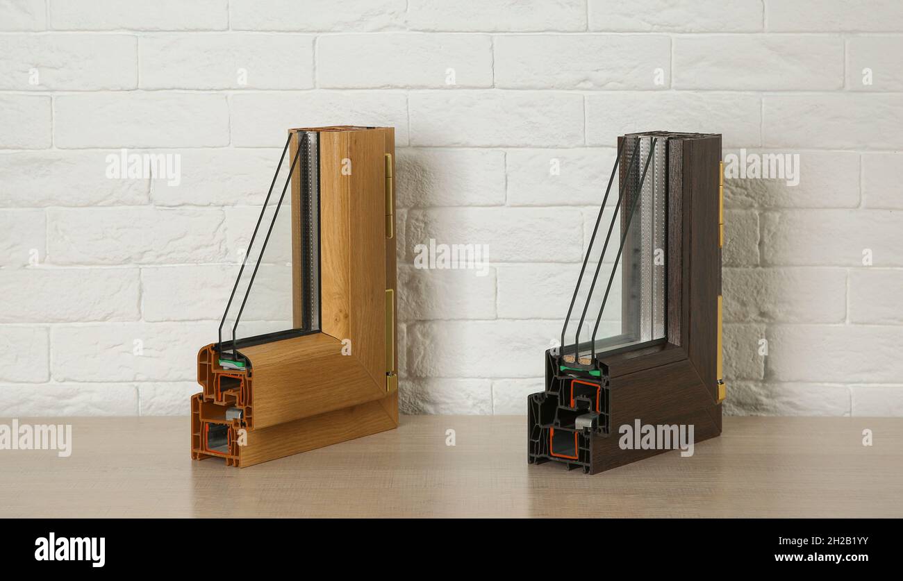Samples of modern window profiles on table against brick wall ...