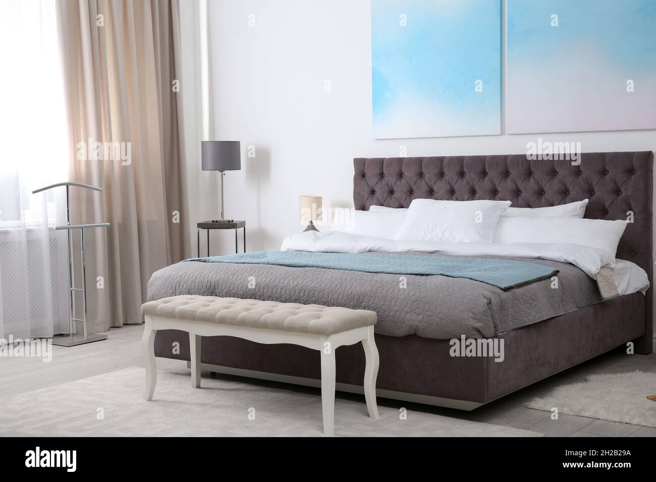 Stylish room interior with large comfortable bed Stock Photo - Alamy