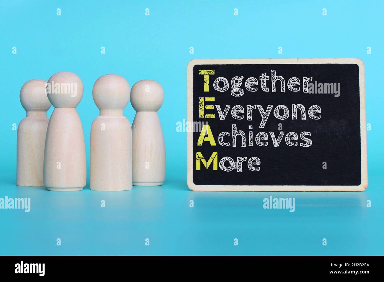Teamwork concept. Wooden dolls with text TEAM, TOGETHER EVERYONE ...