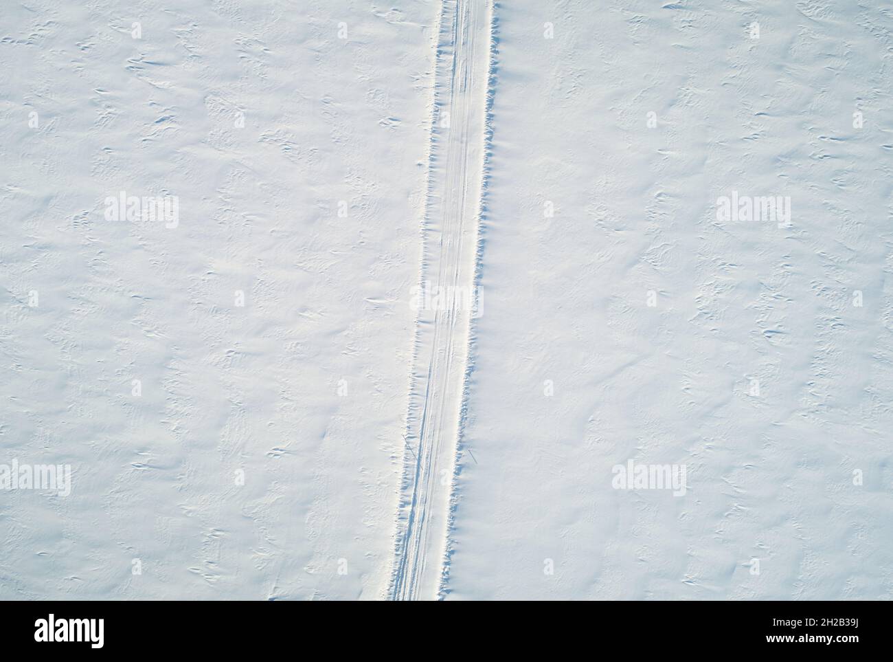 Covered with snow road path in winter field background above top drone ...