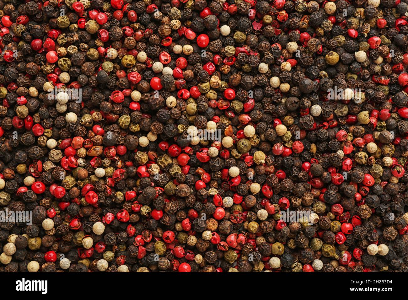 Different types of pepper as background. Natural spice Stock Photo - Alamy