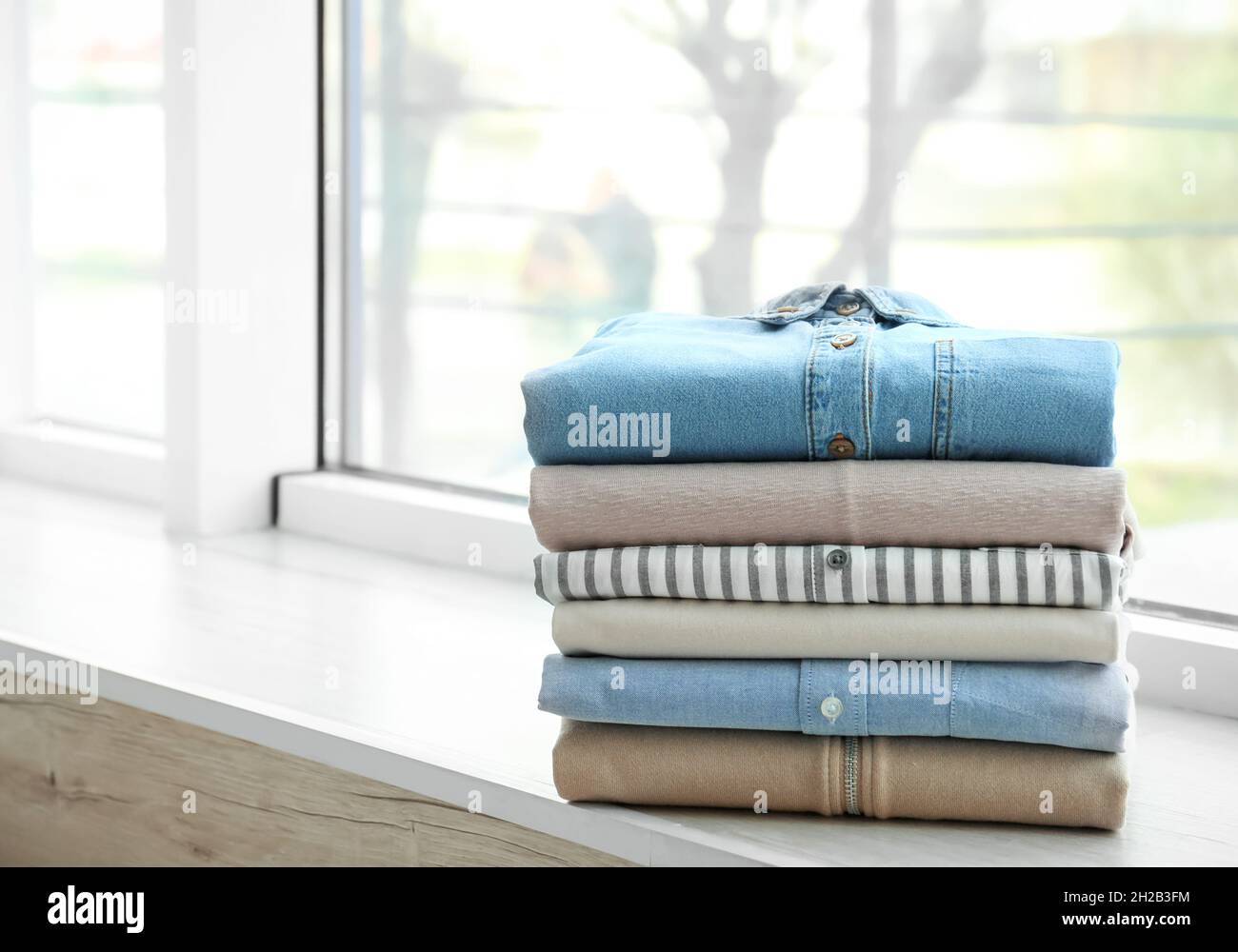 Stack of clean clothes on window sill Stock Photo - Alamy