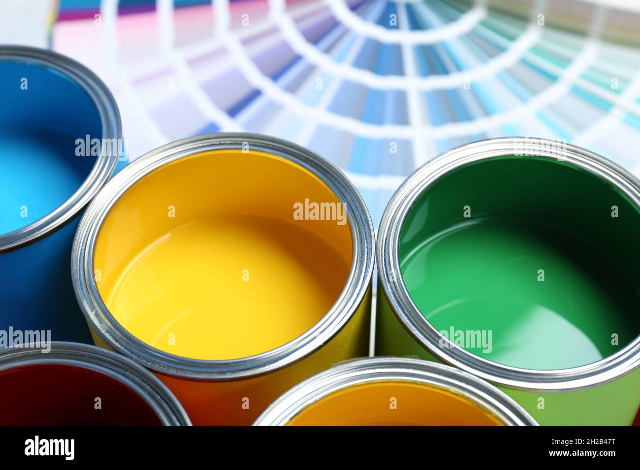 Paint cans and color palette samples on table, closeup Stock Photo - Alamy