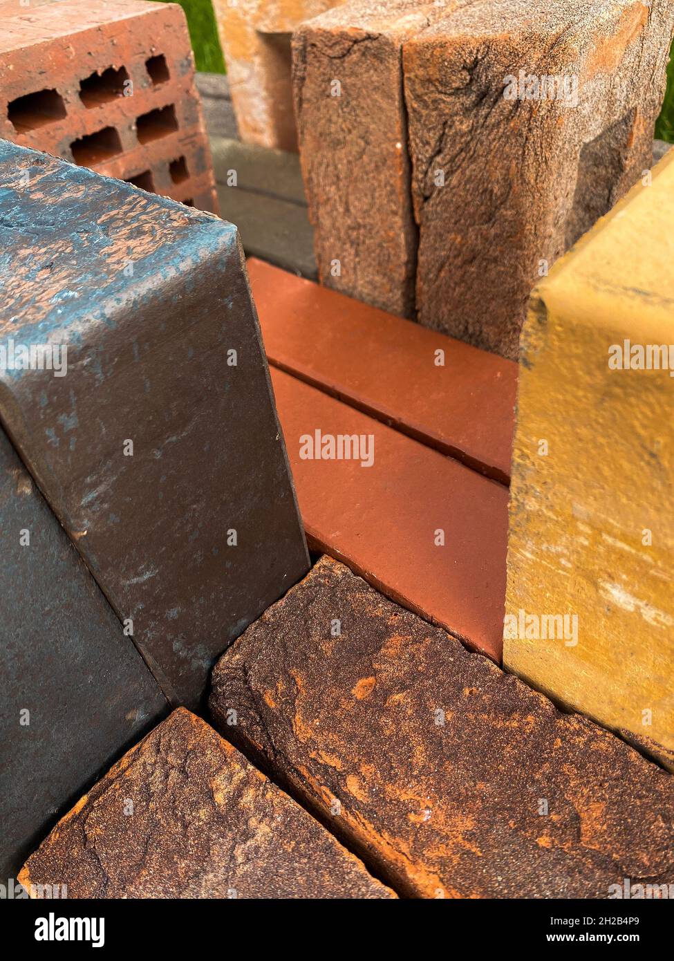 Different types of bricks stacked beautifully on green grass Stock ...