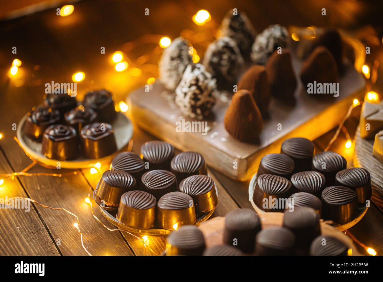 Assorted chocolates on wooden table with garland Stock Photo - Alamy