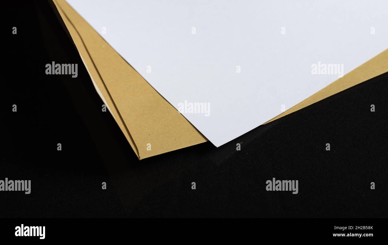 Closeup of a paper sheet and an envelope isolated on a black background ...