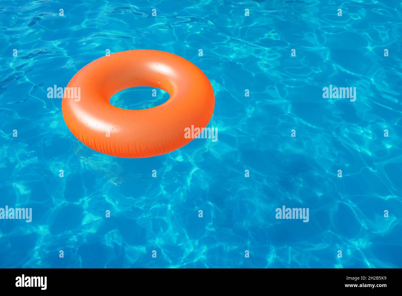 Inflatable ring floating in swimming pool on sunny day. Space for text ...