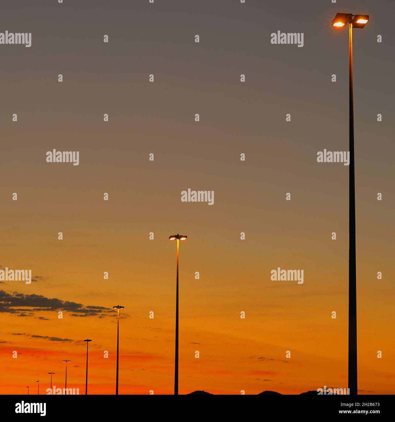 Street lights in front of sunset sky in fire colors, red, orange ...