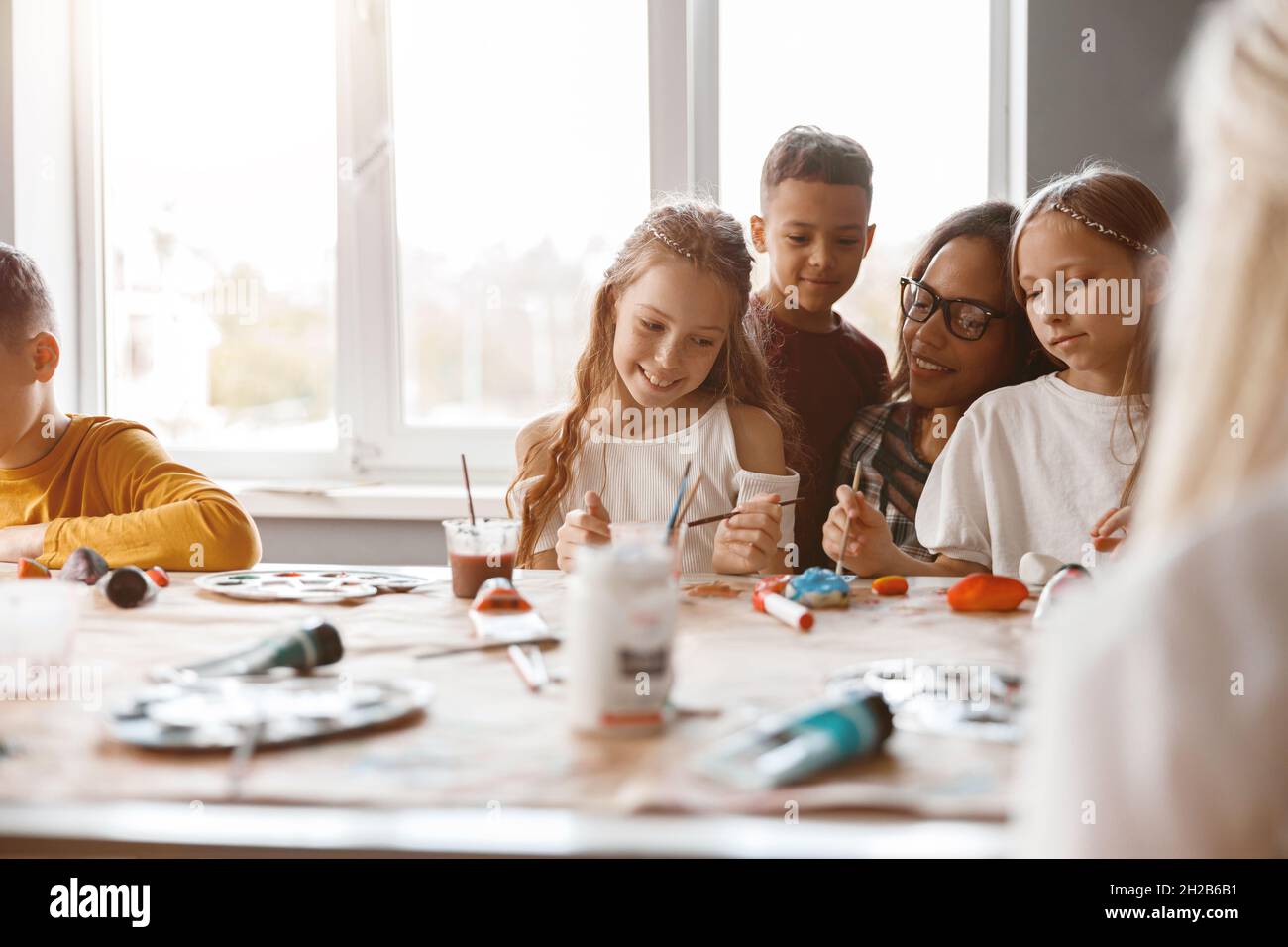 Smiling classmates making art painting using water colors Stock Photo ...
