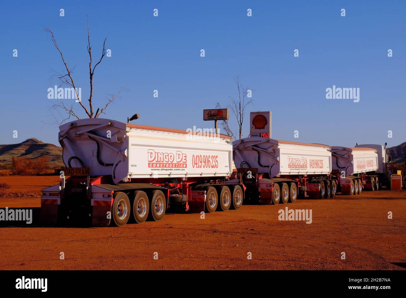Road train and red earth soon before sunset at Auski Roadhouse and ...