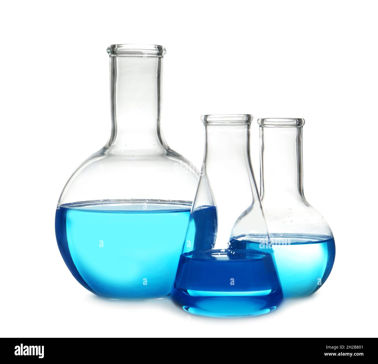 Laboratory glassware with liquid on table against white background ...