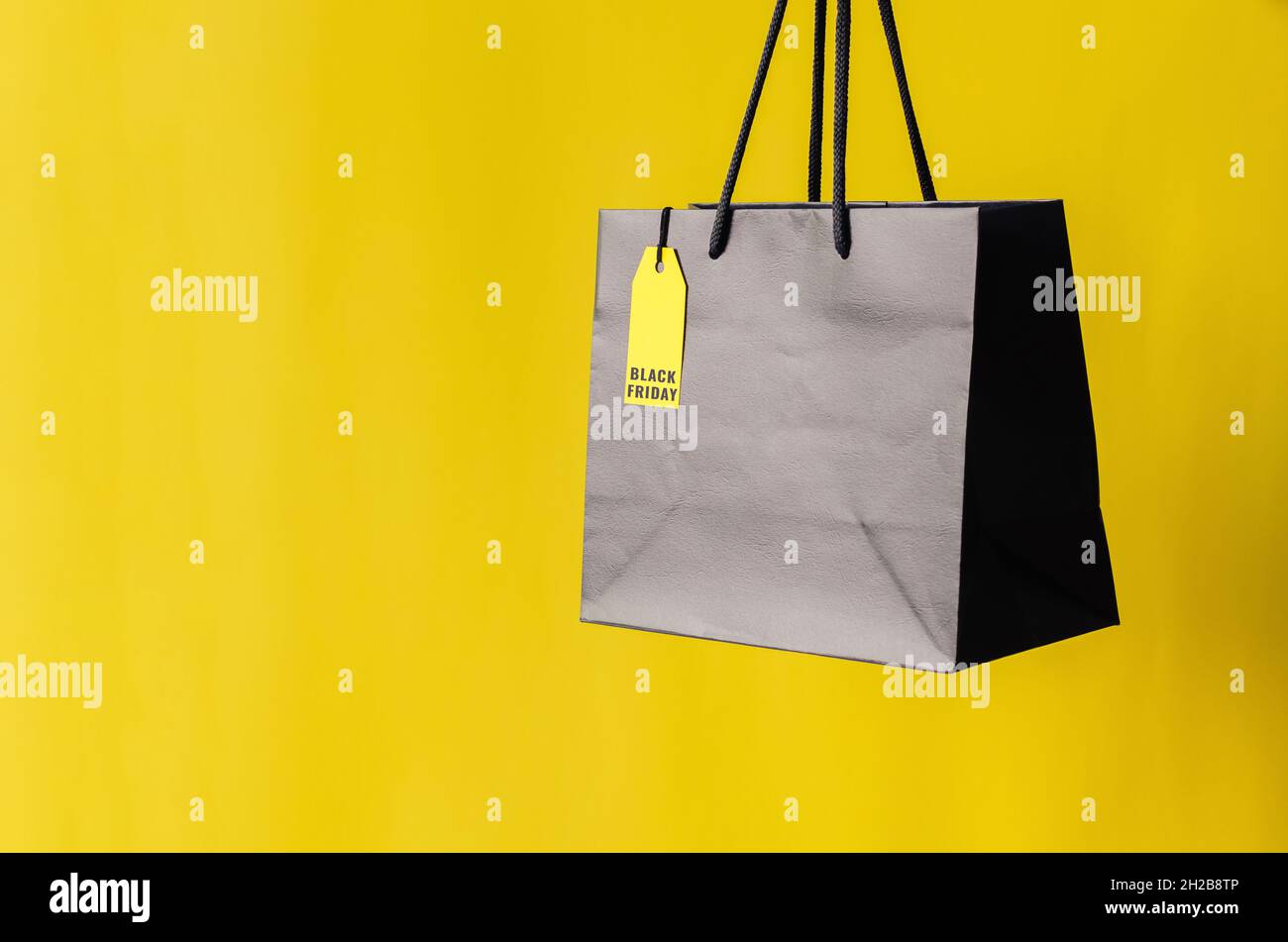 Black shopping bag with yellow price tag with yellow background for ...