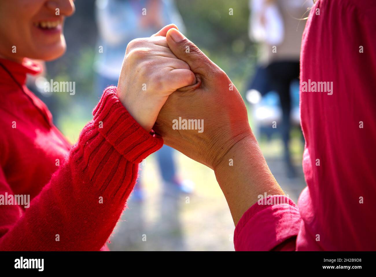 Two women holding hands in compassion and love Stock Photo - Alamy