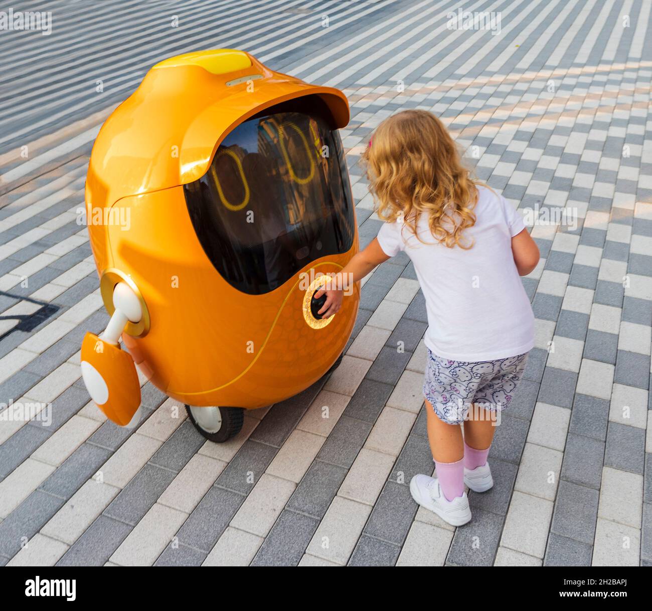 Shot of a little girl playing with cute small robot. Technology Stock ...