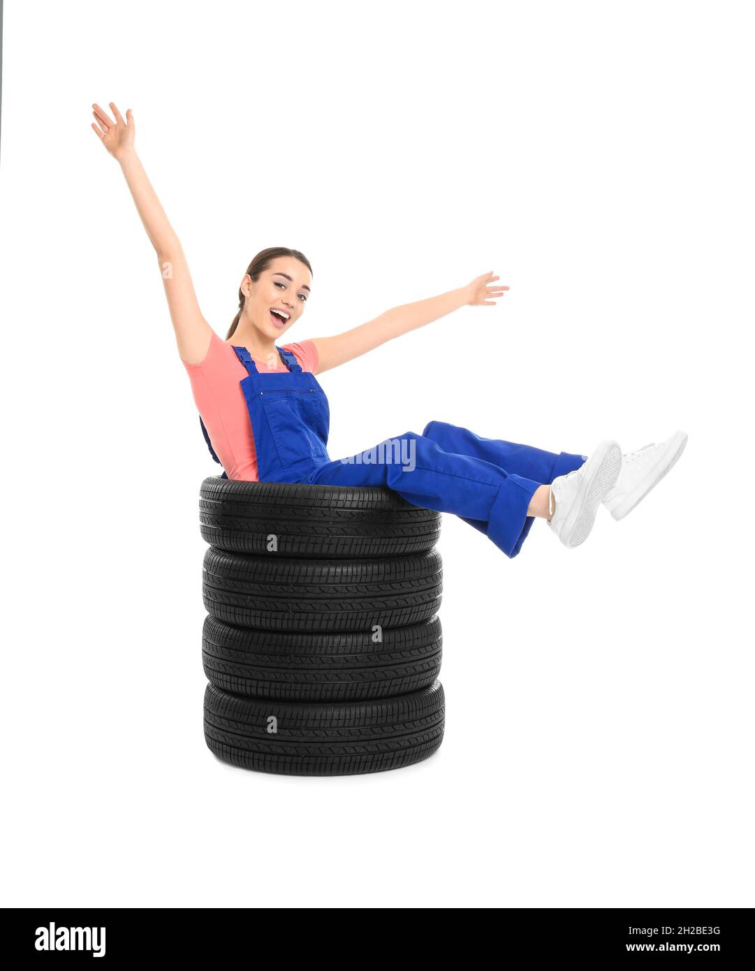 Female mechanic in uniform with car tires on white background Stock ...
