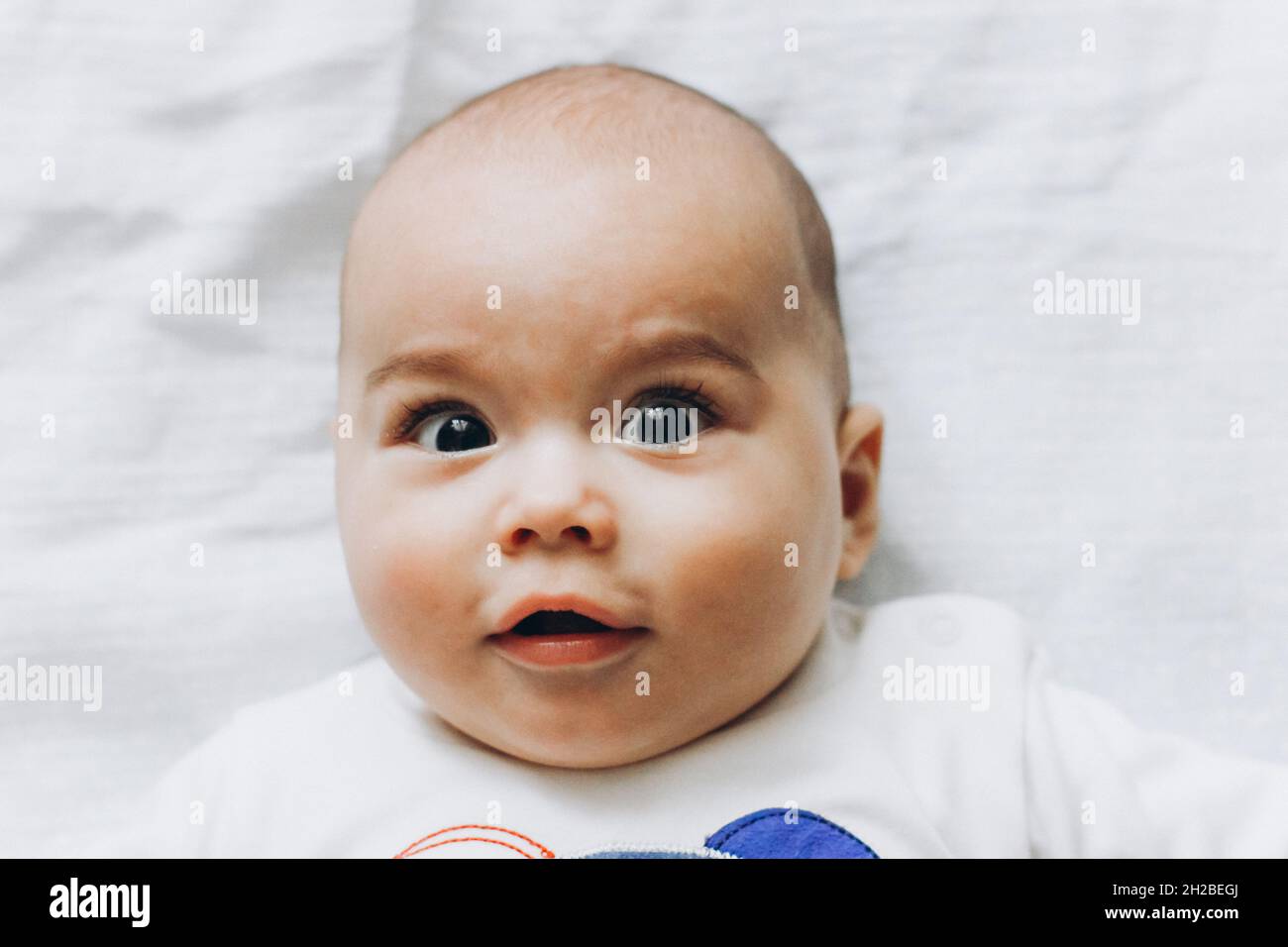 Sweet little baby boy with chubby cheeks and big eyes. Portrait of ...