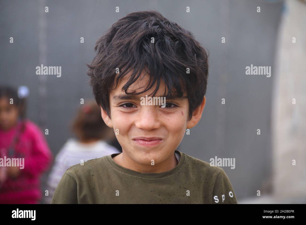A portrait of a sweet refugee child in the camp. Syrian refugees Stock ...