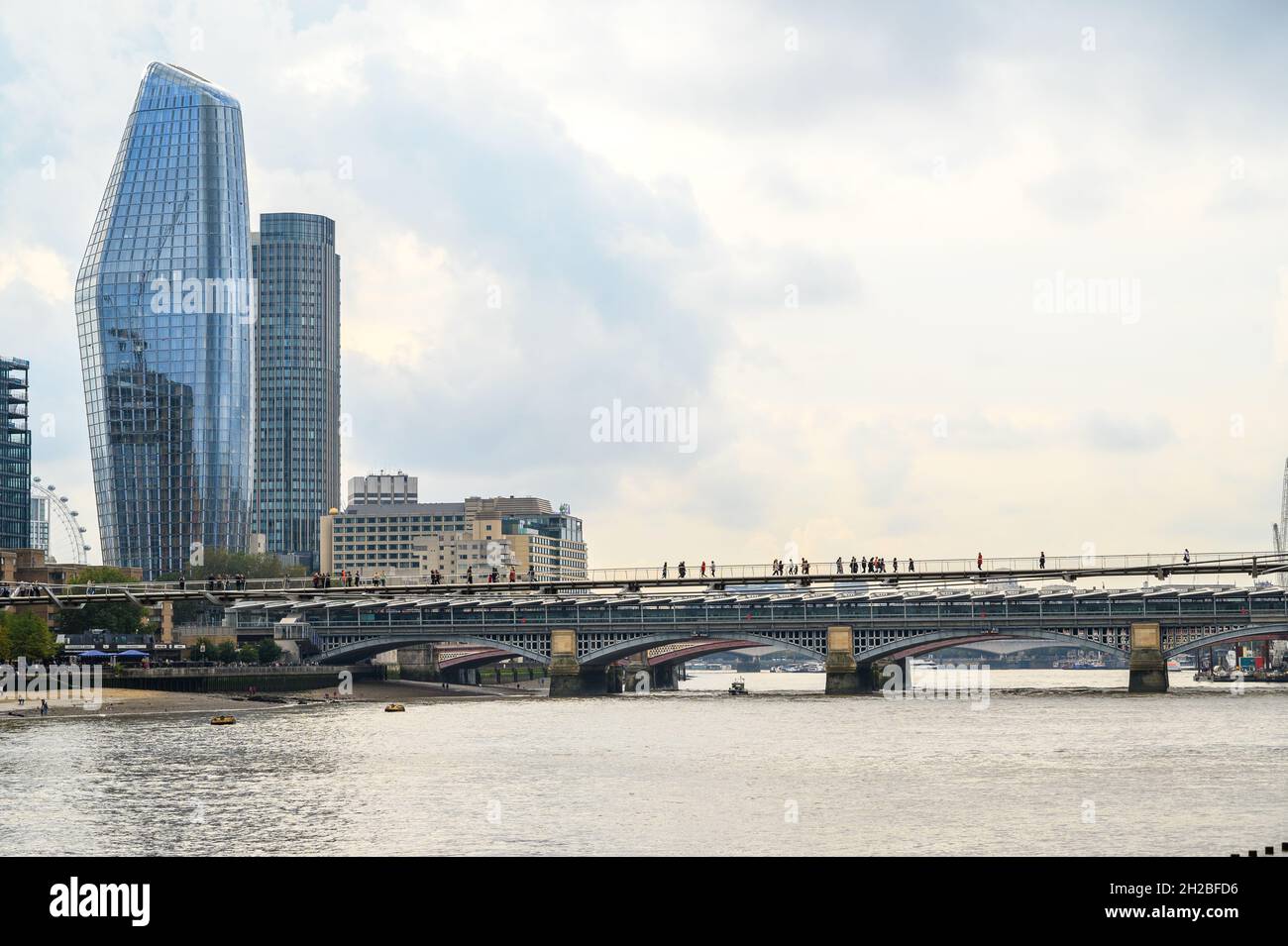 People walking across the Millennium Bridge over River Thames with The ...