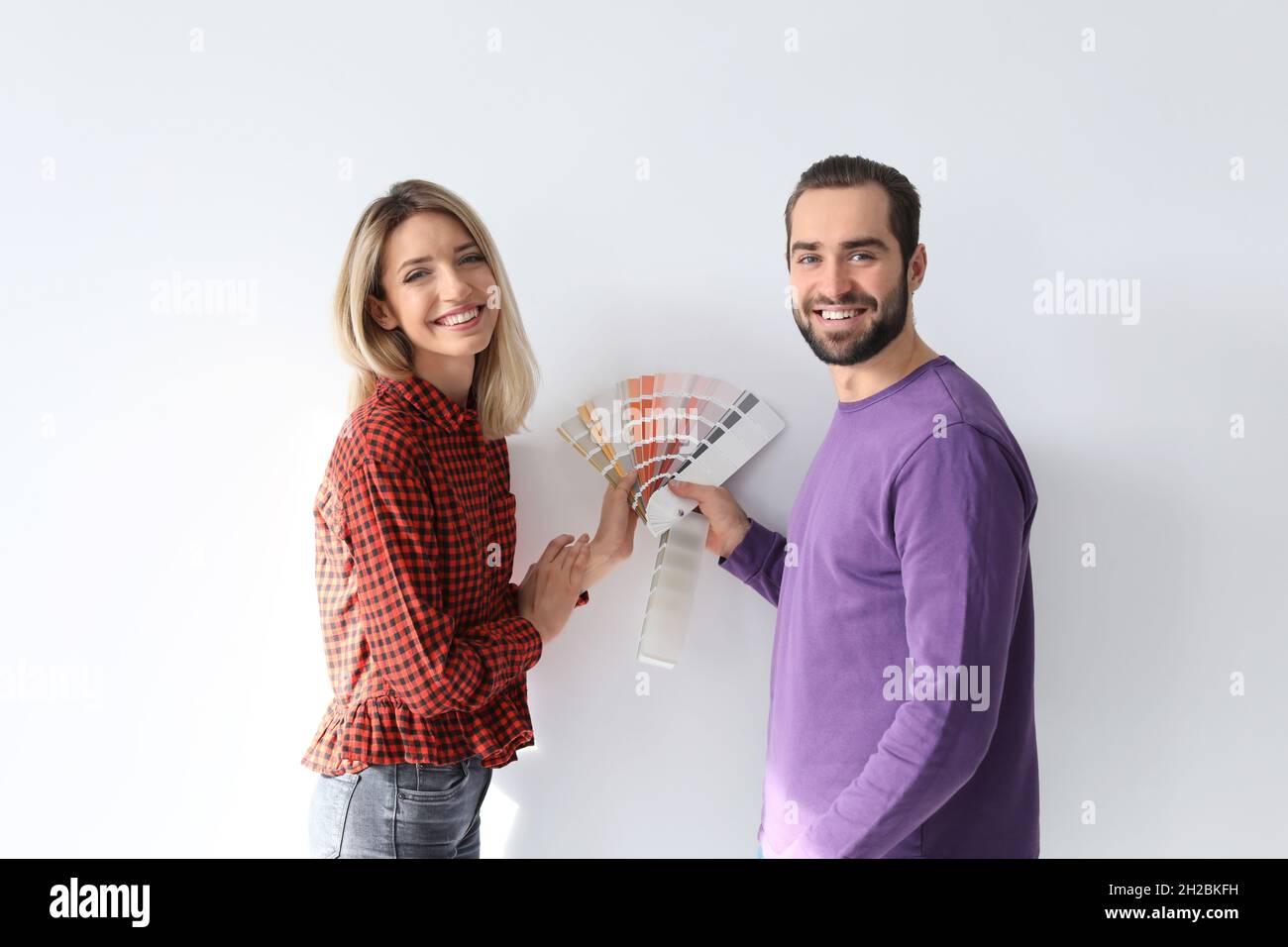 Young couple with color palette on white background Stock Photo - Alamy