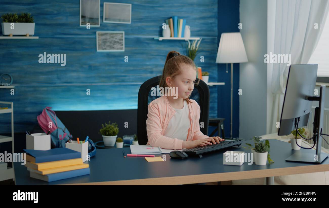 Pupil drawing on notebook with colorful pencils and using computer ...