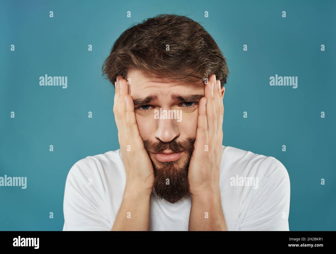 Man in a white t-shirt irritated facial expression Studio Stock Photo ...