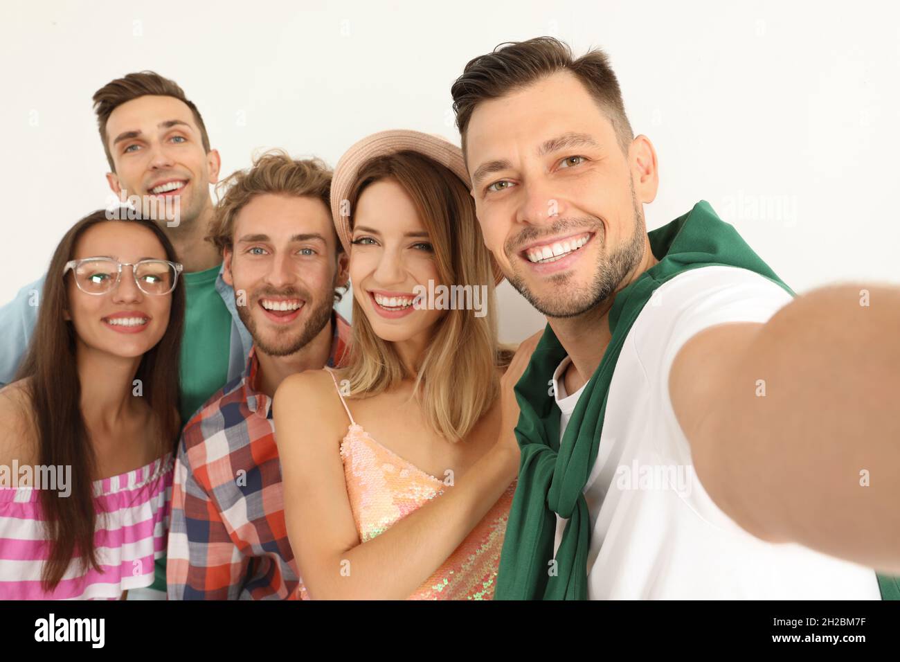 Group of happy young people taking selfie on white background Stock Photo - Alamy