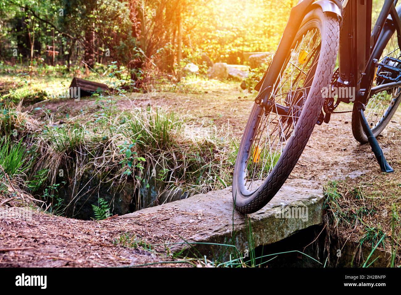 Bicycle on a narrow stone bridge over a ditch, parked on a bike ride ...