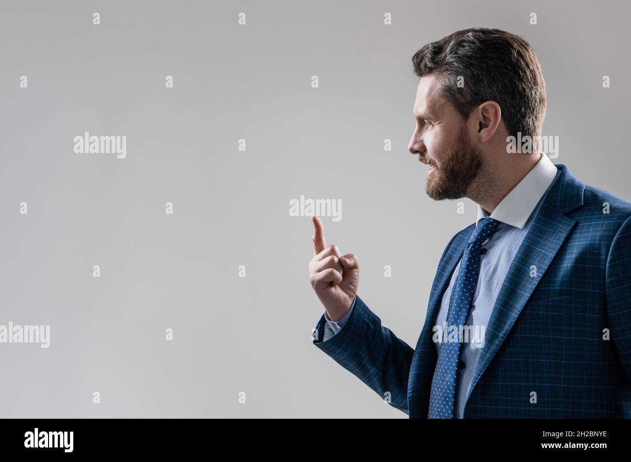Professional man in suit sideway keep finger pointing up grey ...