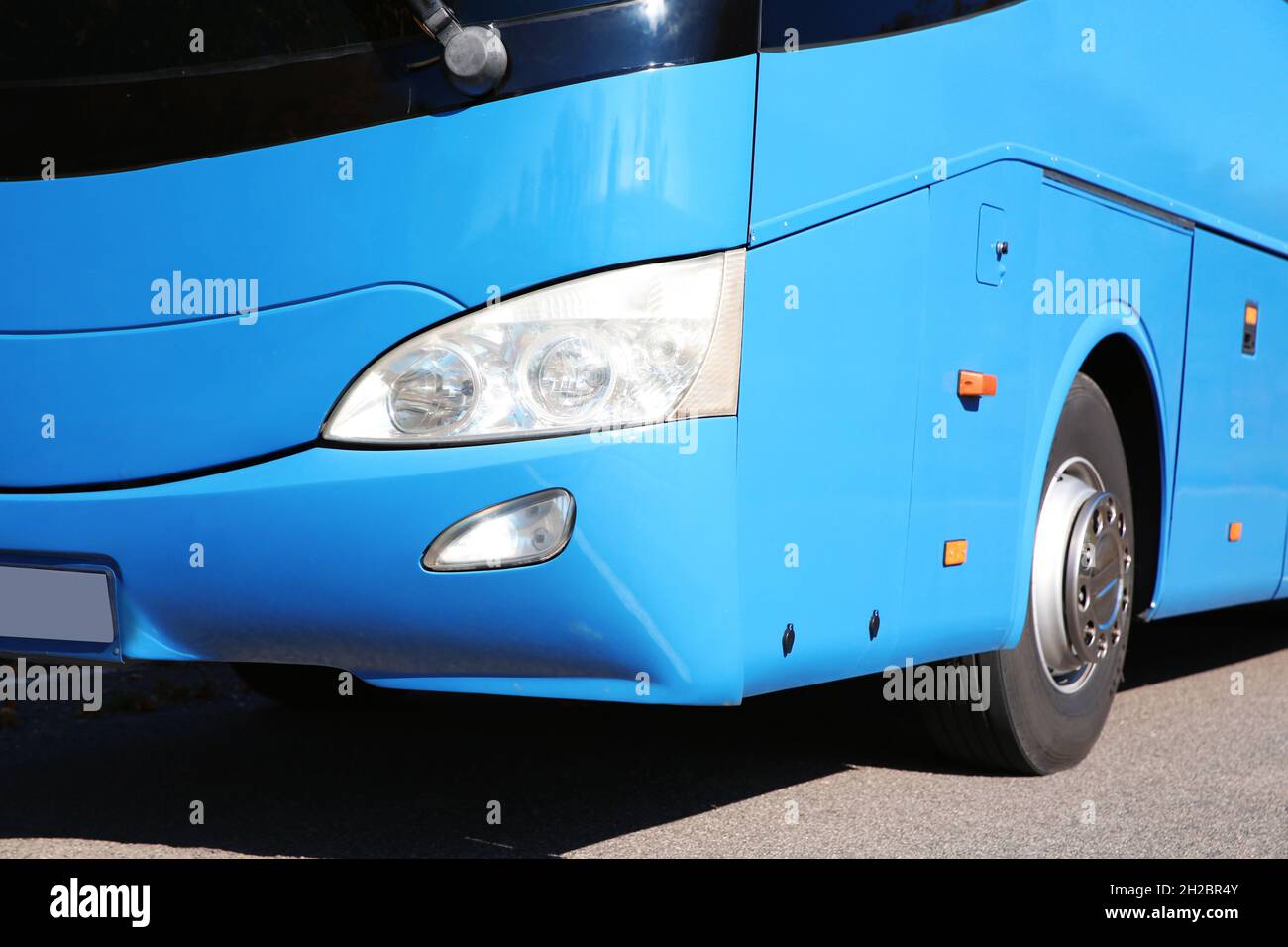 Modern blue bus on road, focus on headlight. Passenger transportation ...