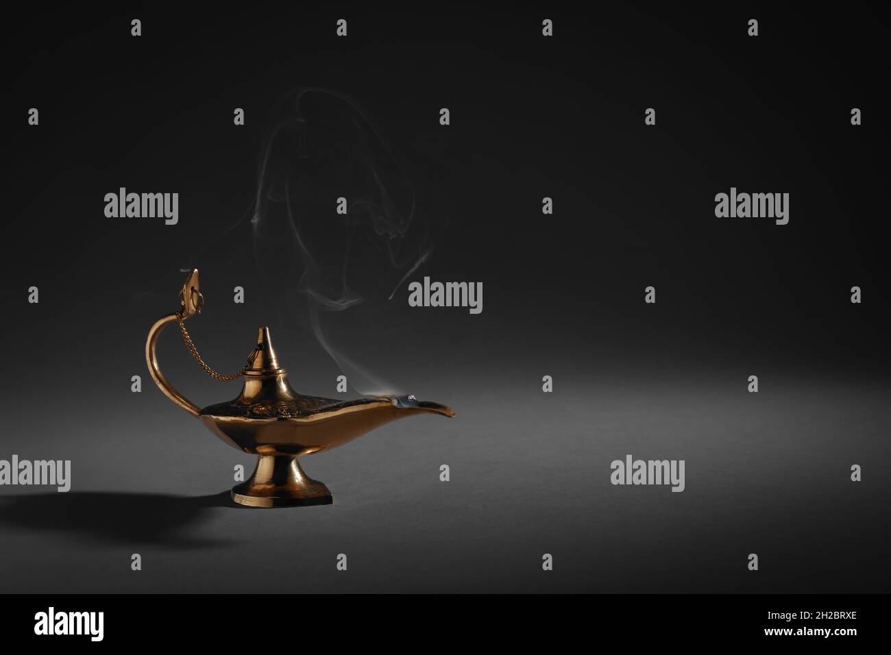 Aladdin magic lamp on dark background Stock Photo - Alamy