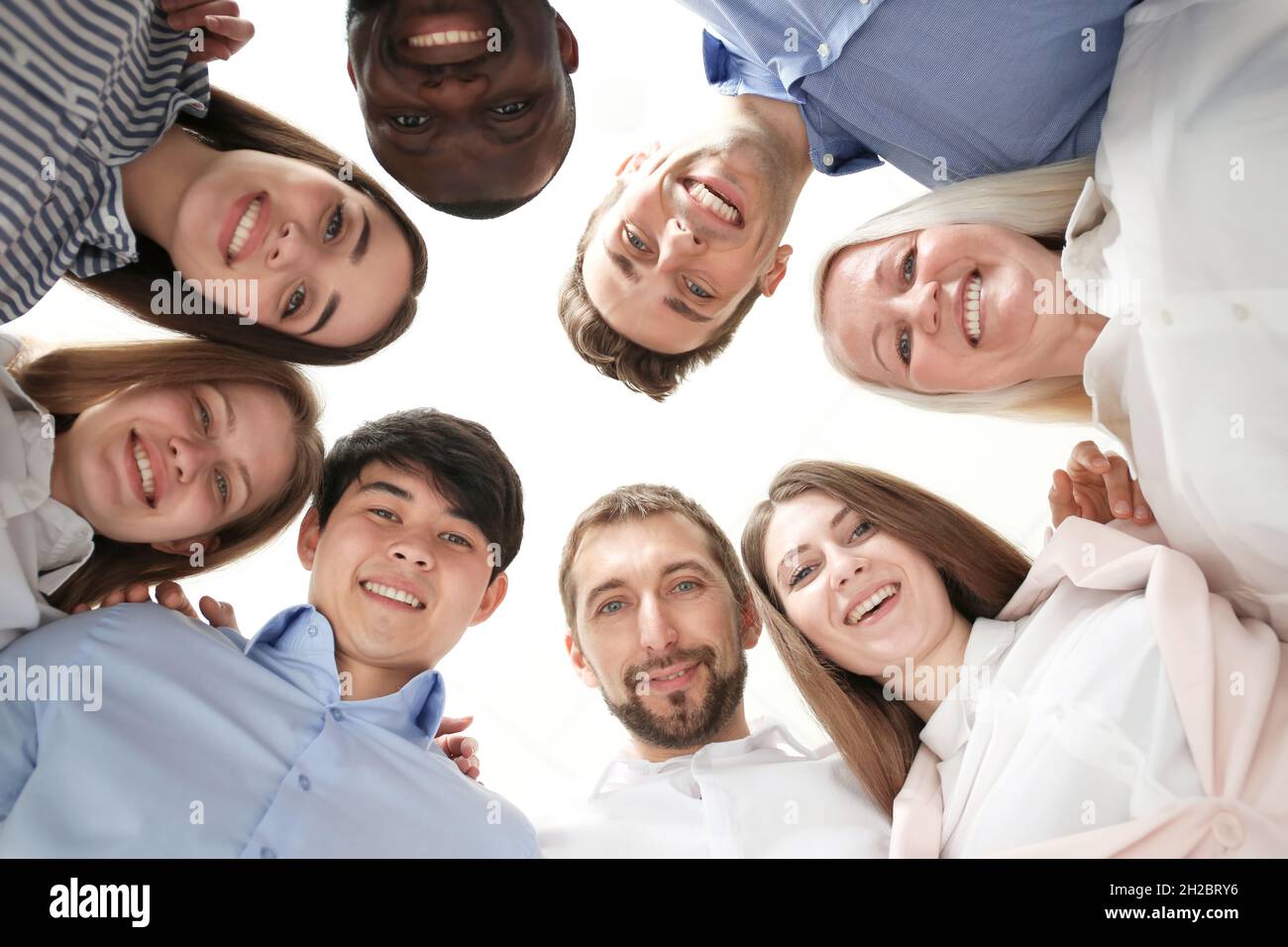 People standing together against light background, bottom view. Unity ...