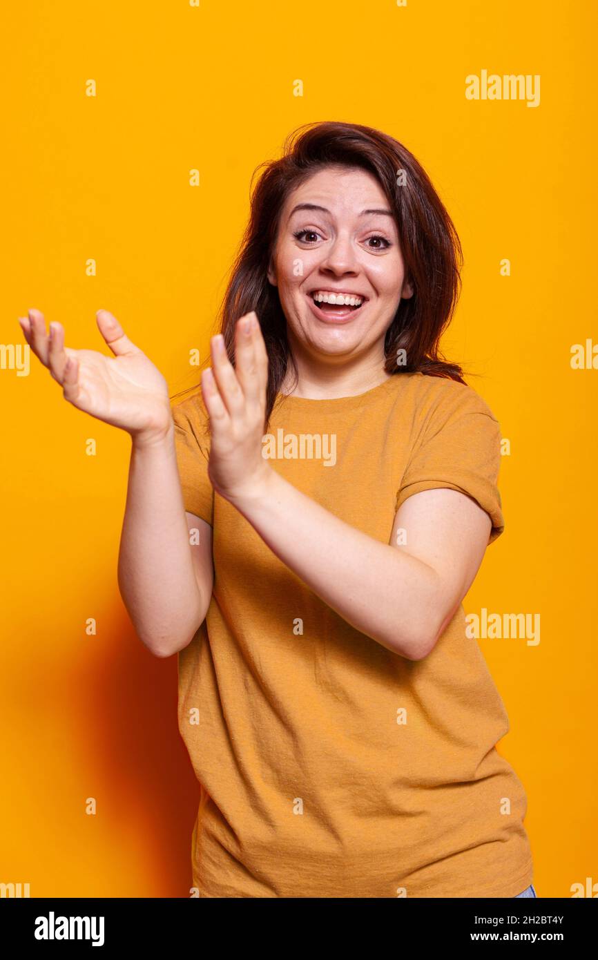 Cheerful woman clapping hands to celebrate achievement, looking at ...