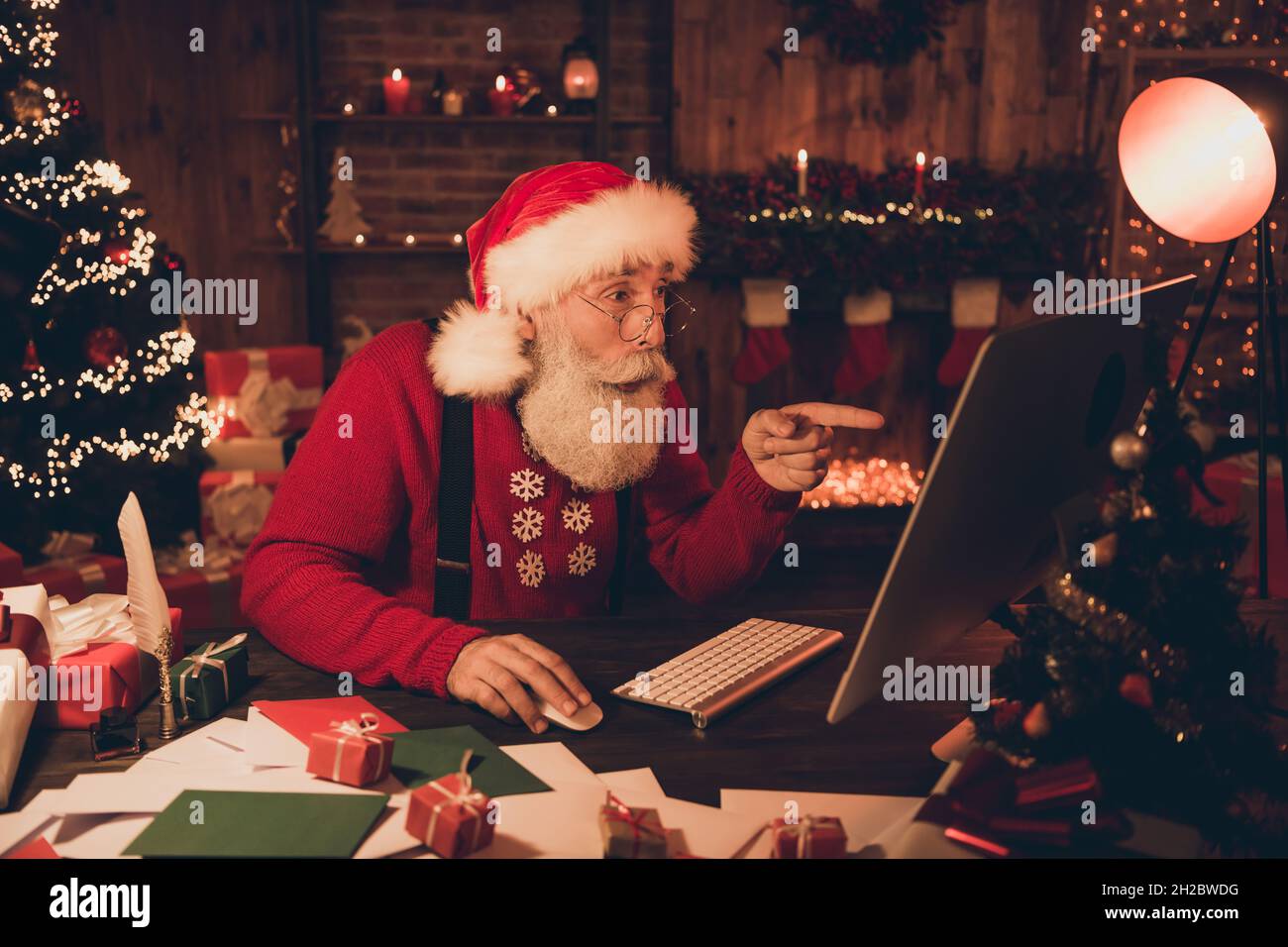 Photo portrait cheerful smiling santa pointing finger on computer ...