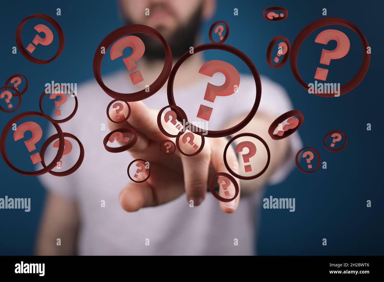 Male pointing at question mark bubbles Stock Photo - Alamy