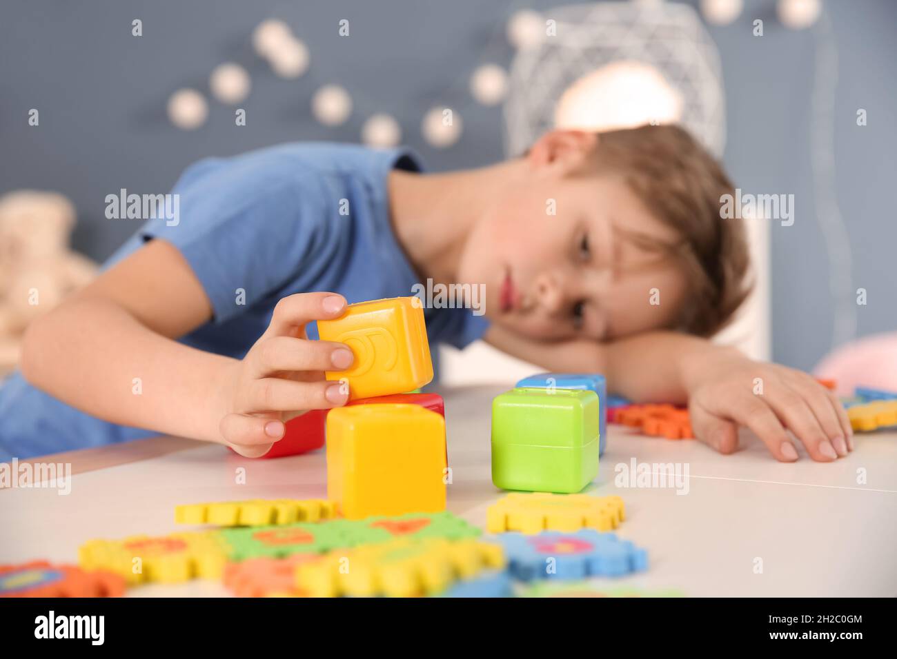 Little boy with autistic disorder playing at home, closeup of cubes ...