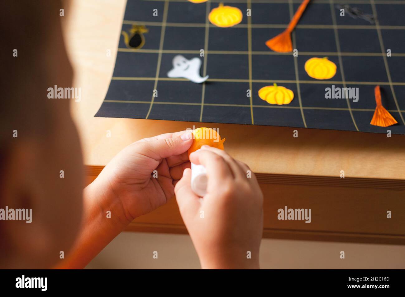 Preschooler boy making board game field for Halloween game, child ...