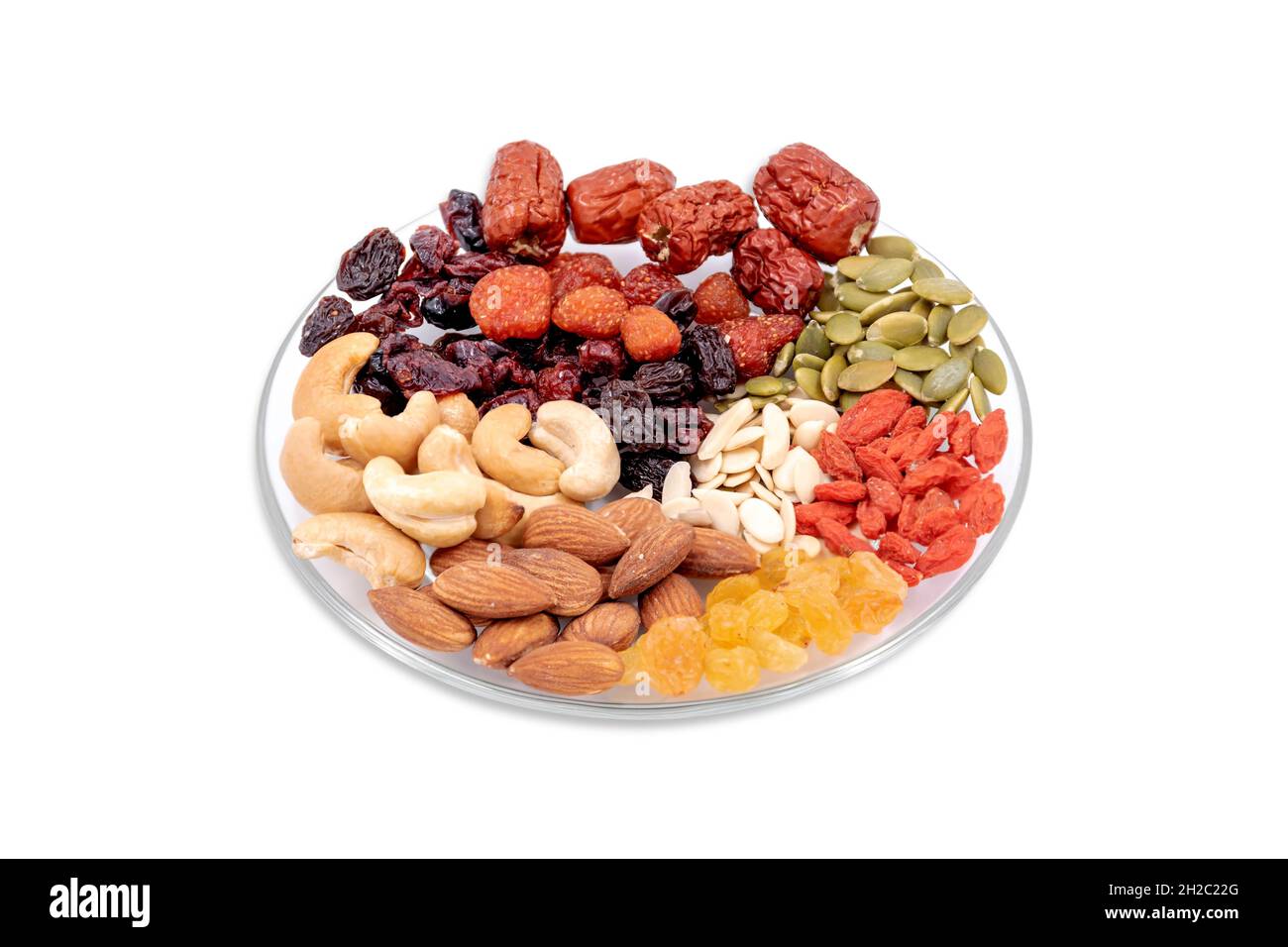 Group of whole grains and dried fruit in a glass plate isolated on ...