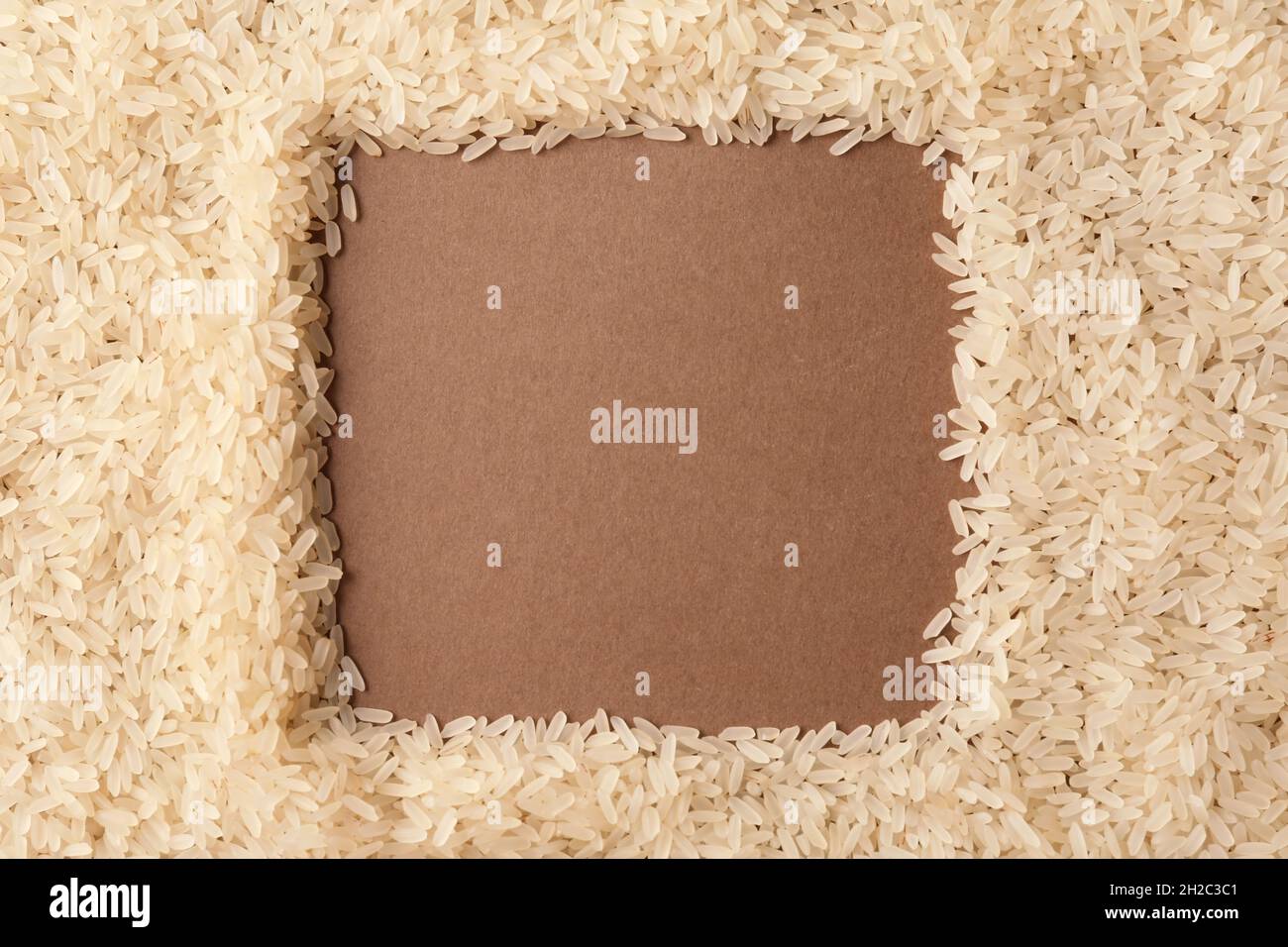 Frame made with parboiled rice on color background, top view. Space for ...