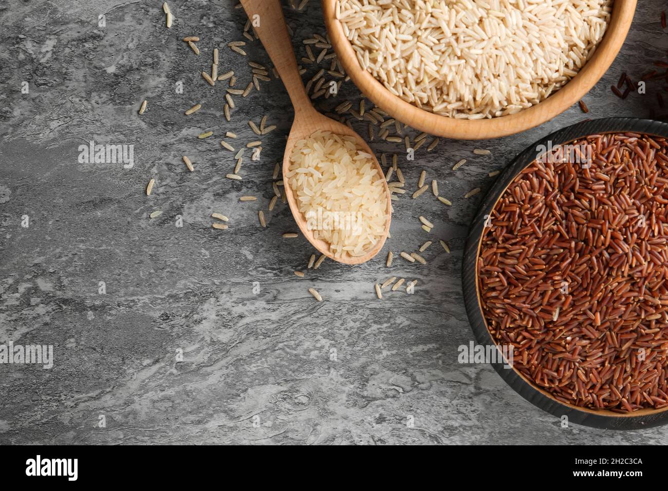 Flat lay composition with brown and other types of rice on grunge ...