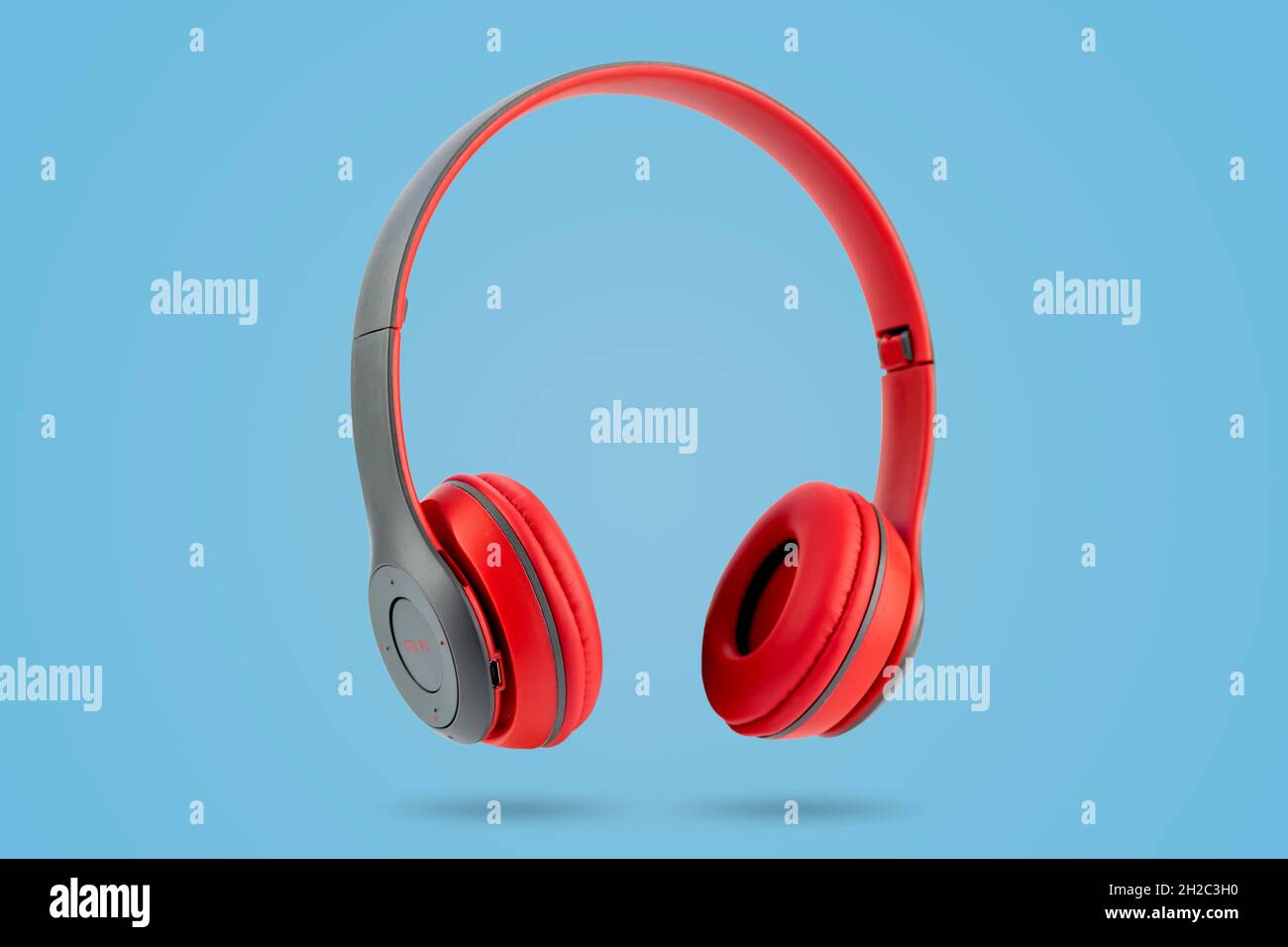 Modern design of red color wireless earphones isolated on blue pastel ...