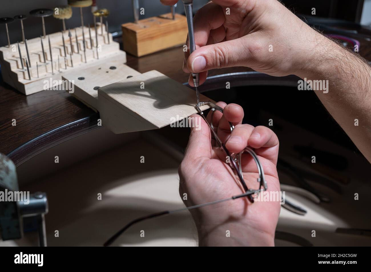Optical technician fixing glasses. Close-up of male hands with ...