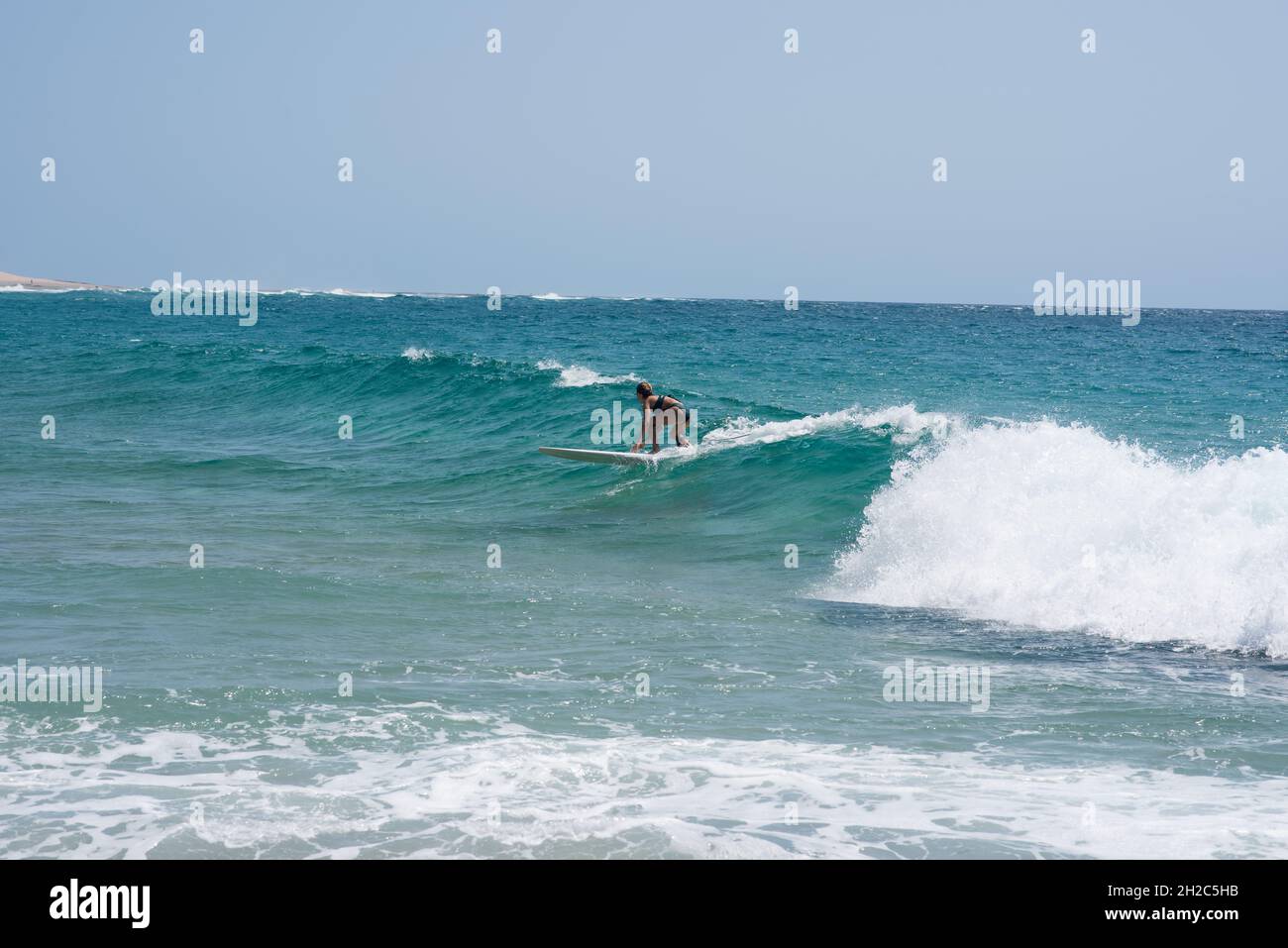 Woman seen riding a surfboard Stock Photo - Alamy