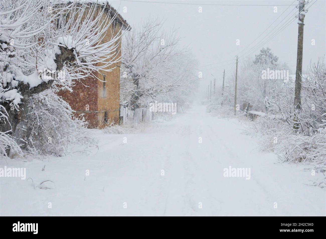 snowy country road with mud house Stock Photo - Alamy