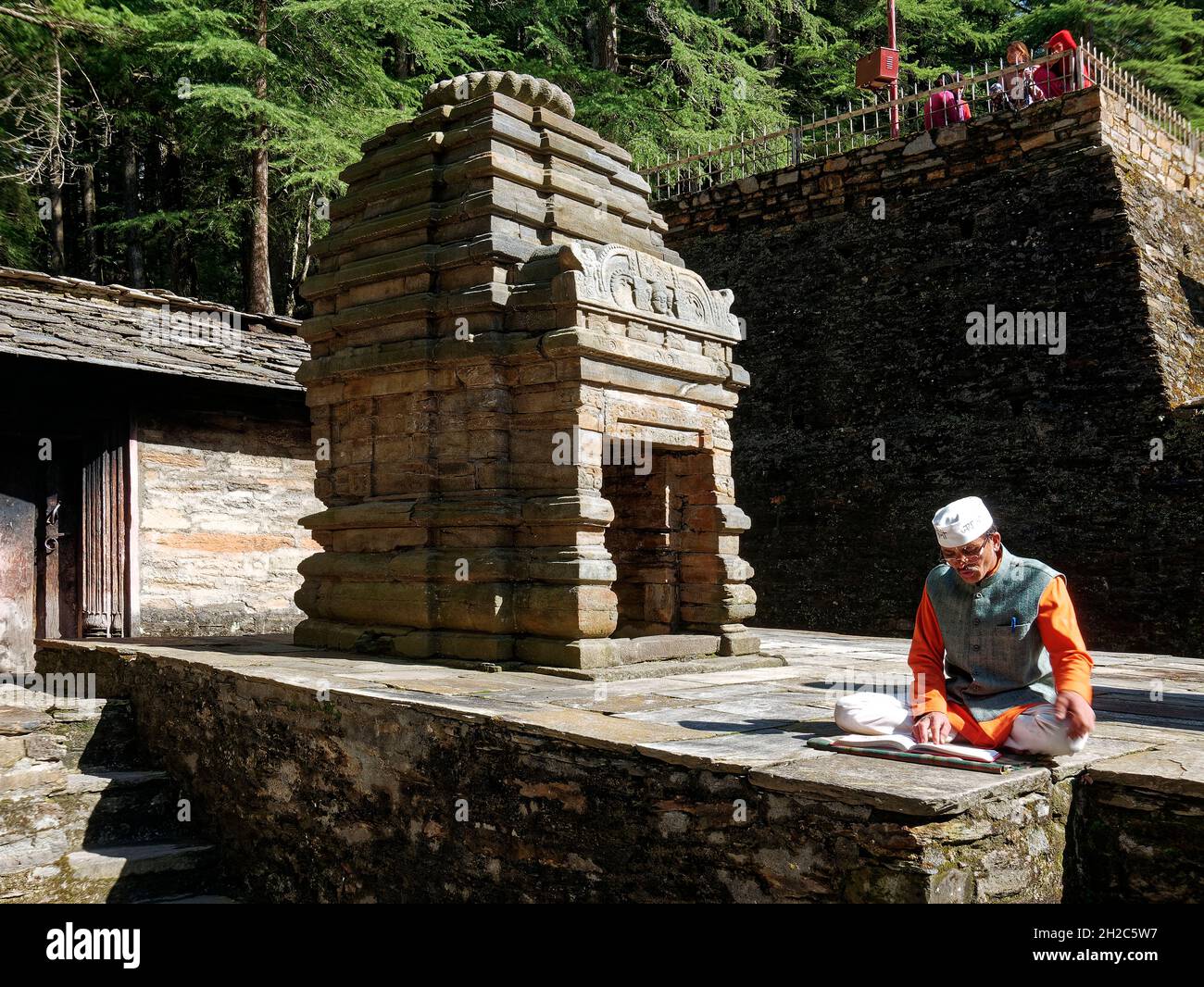 Priest reading sacred book in front of temple Stock Photo - Alamy