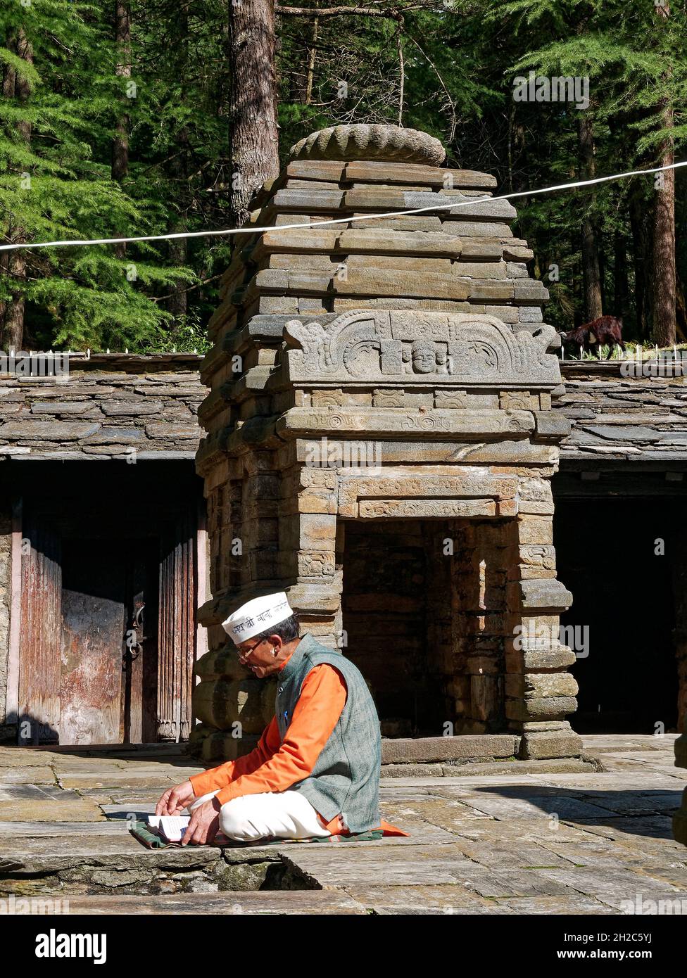 Priest reading sacred book in front of temple Stock Photo - Alamy