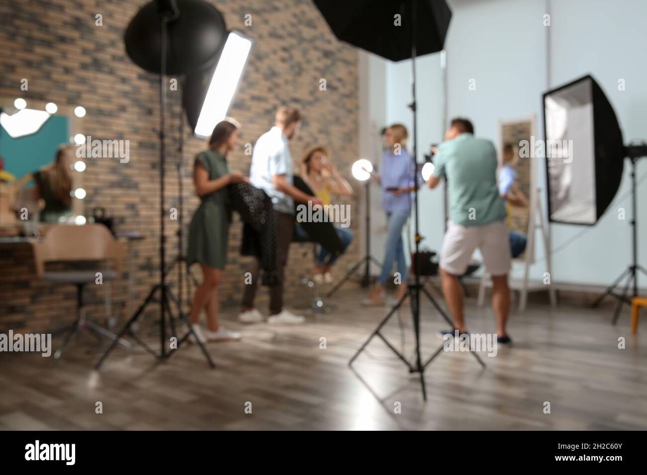 Blurred view of professional team working with model in photo studio ...