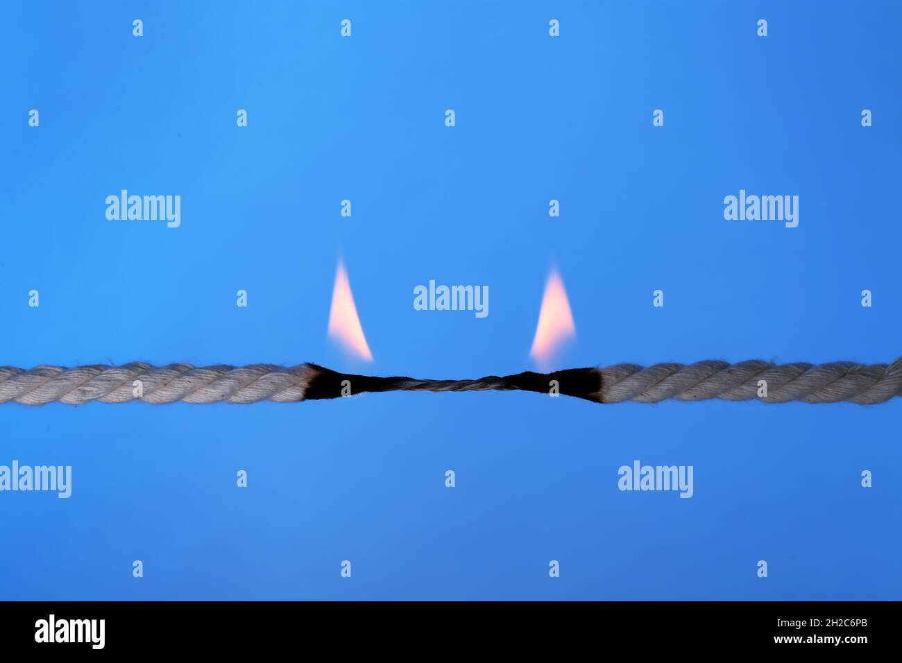 Burning rope at breaking point on color background Stock Photo - Alamy