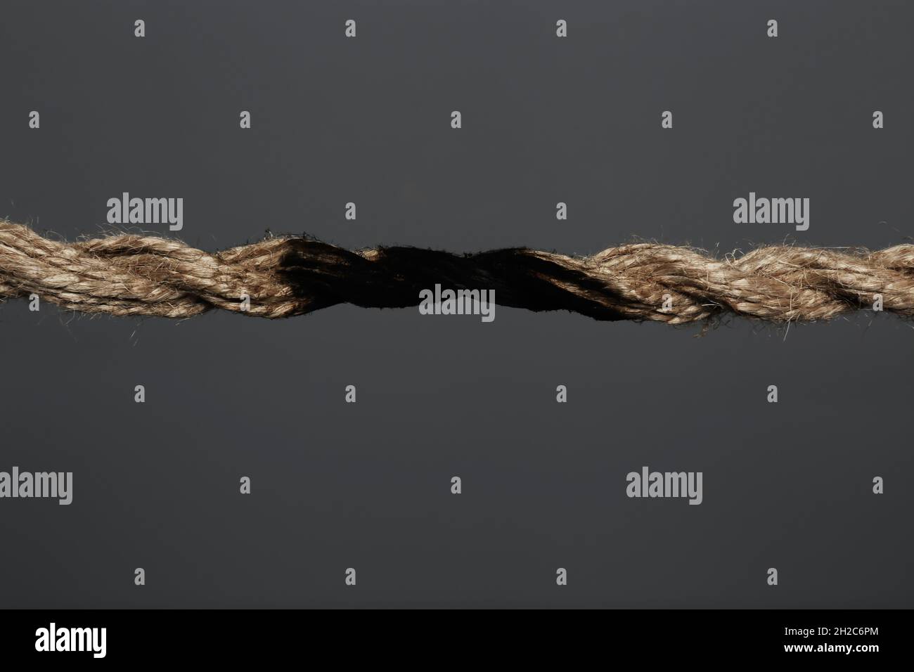 Rope burnt to breaking point on dark background Stock Photo - Alamy