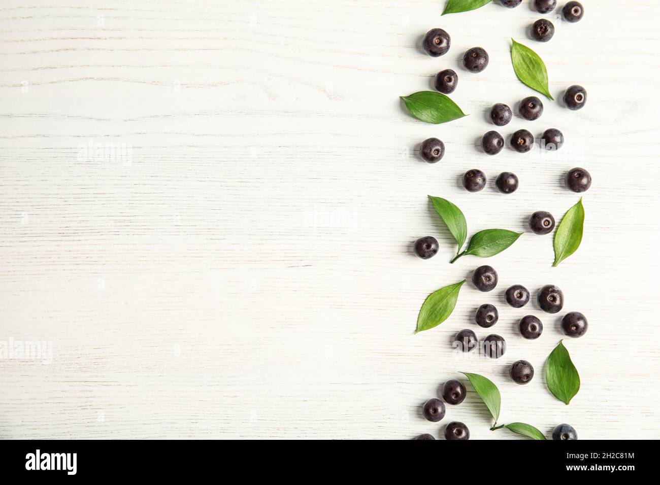 Flat lay composition with fresh acai berries and leaves on wooden ...