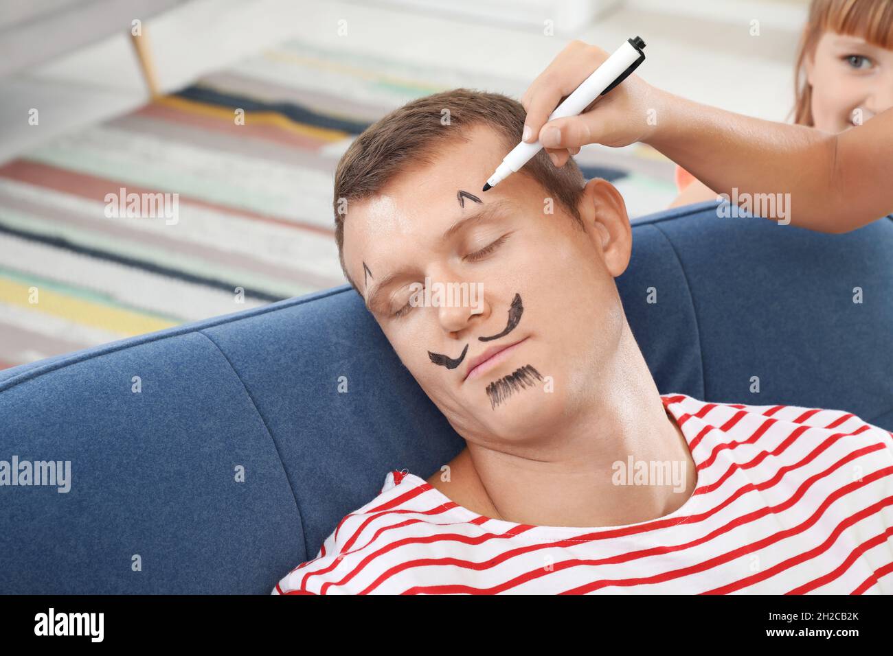 Child painting father's face while he sleeping on April Fool's Day ...